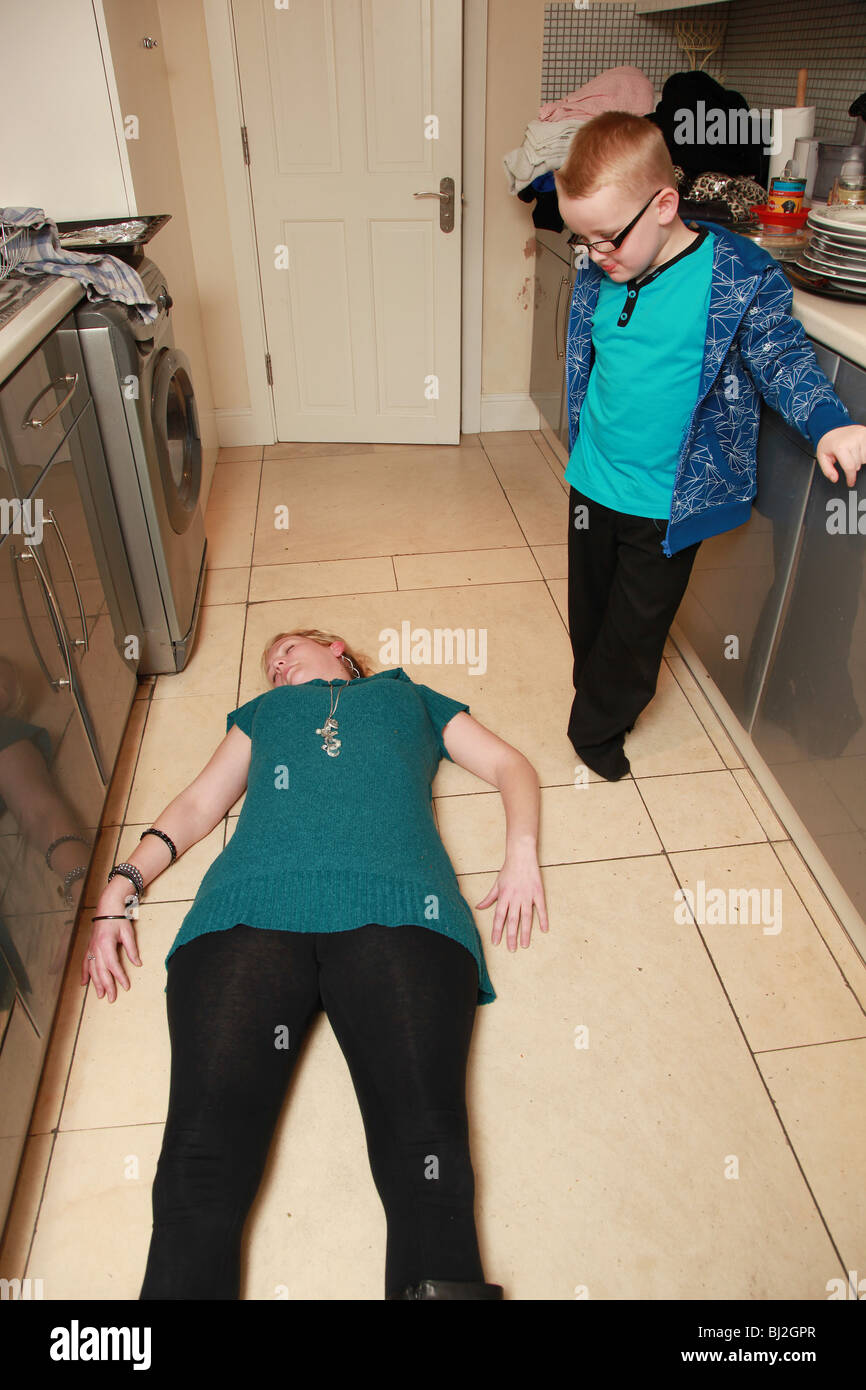 4 year old child in kitchen with mum, who has collapsed Stock Photo - Alamy