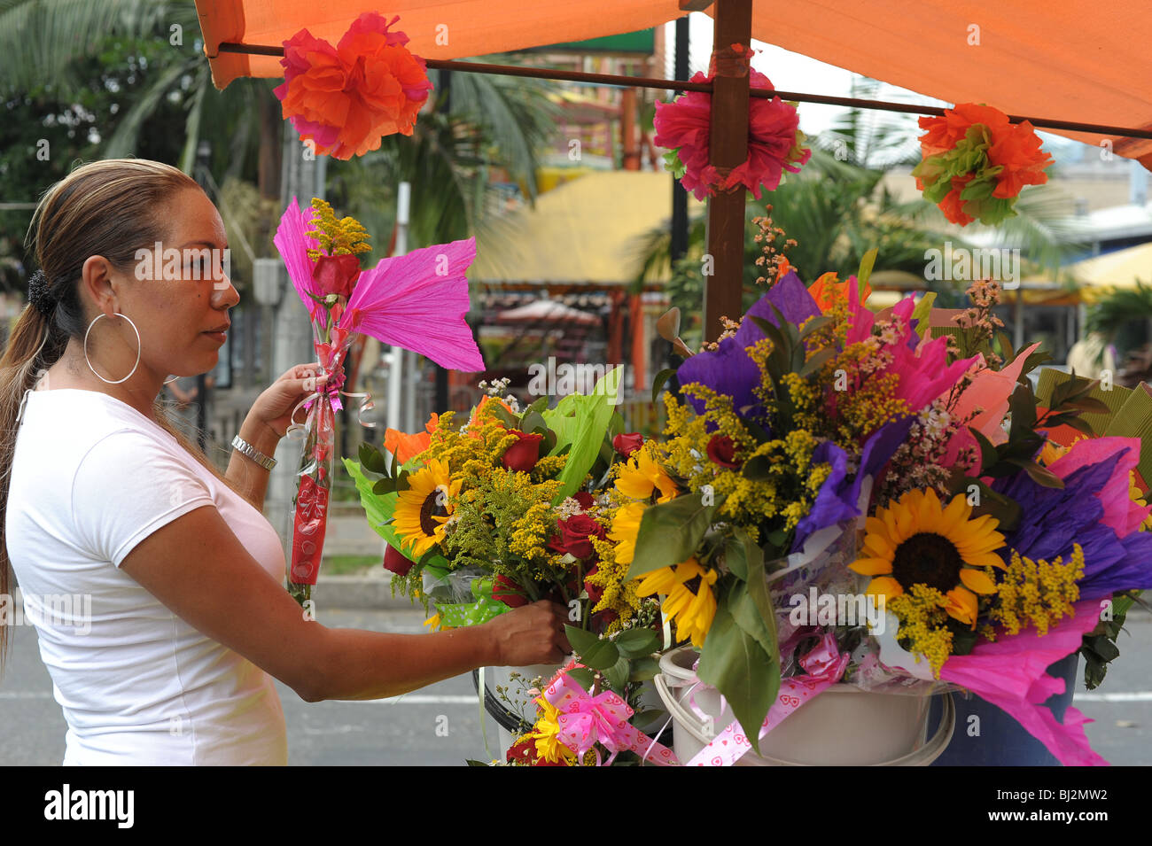 Lady selling flowers at a colorful flower stall in small town Sabaneta ...