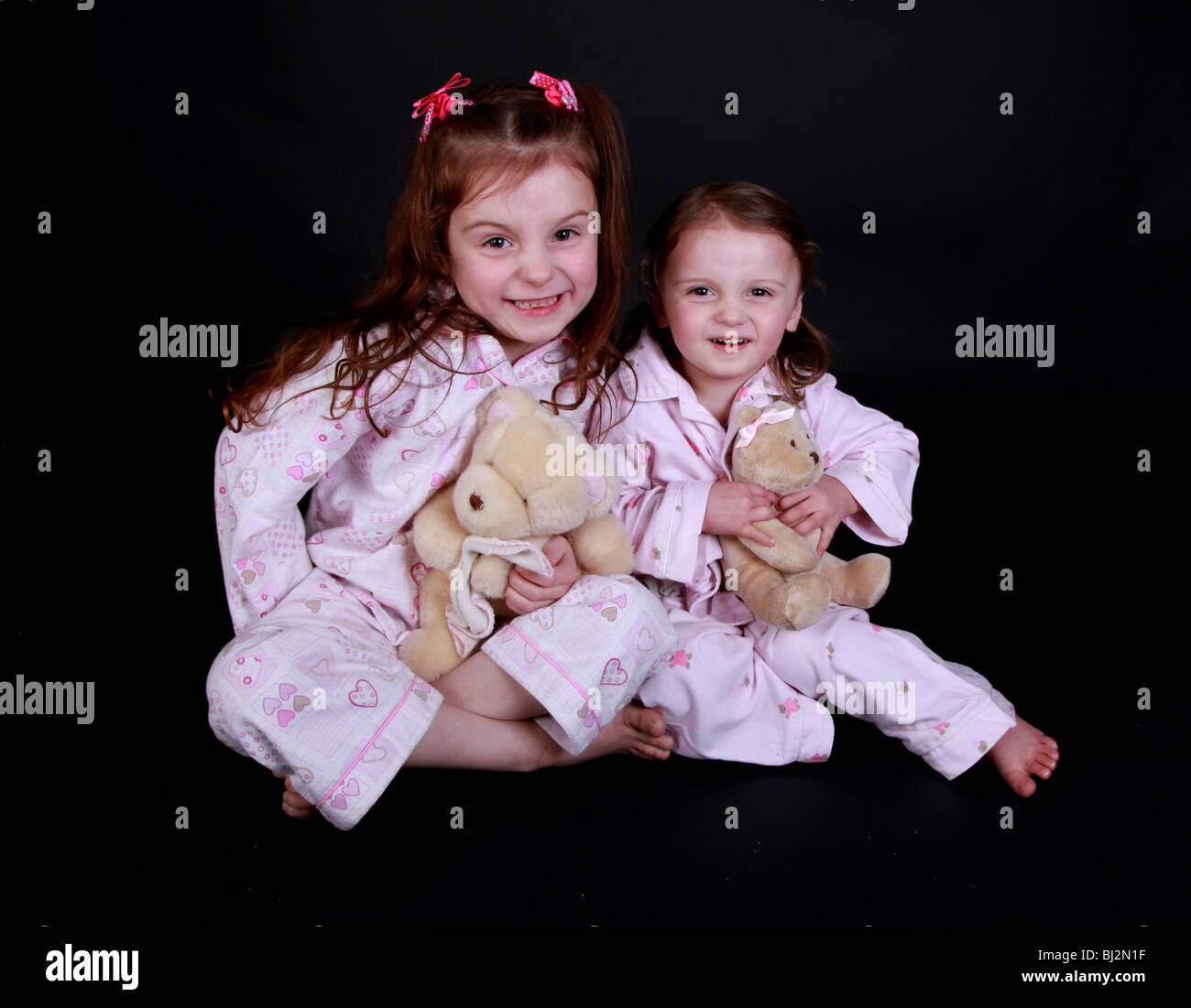 Sisters in pink pyjamas with their teddy bears Stock Photo - Alamy