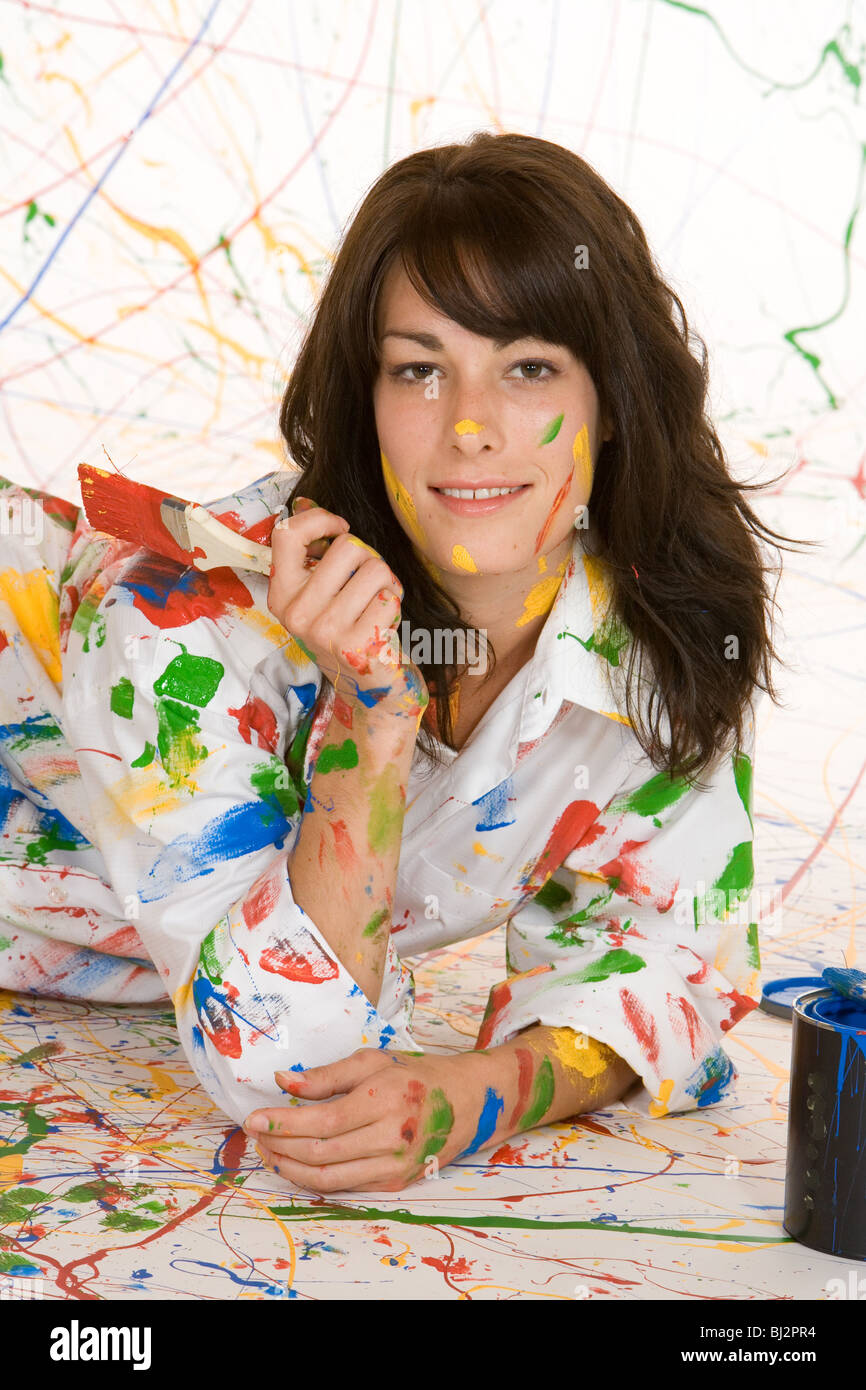 Woman in mid 20s having fun making a mess painting Stock Photo - Alamy