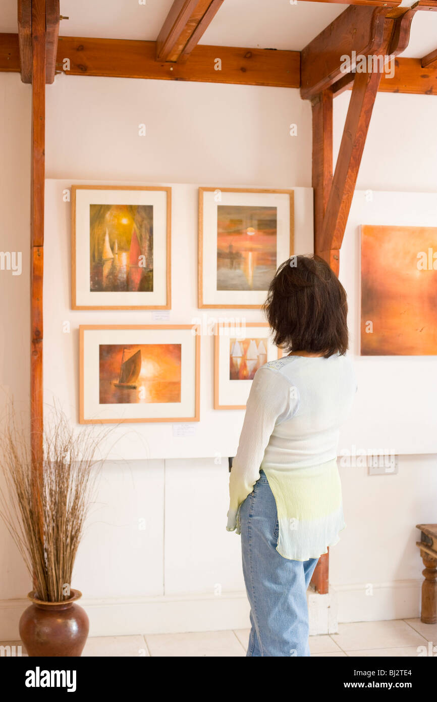 Woman Viewing Artwork in Small Art Gallery Stock Photo - Alamy