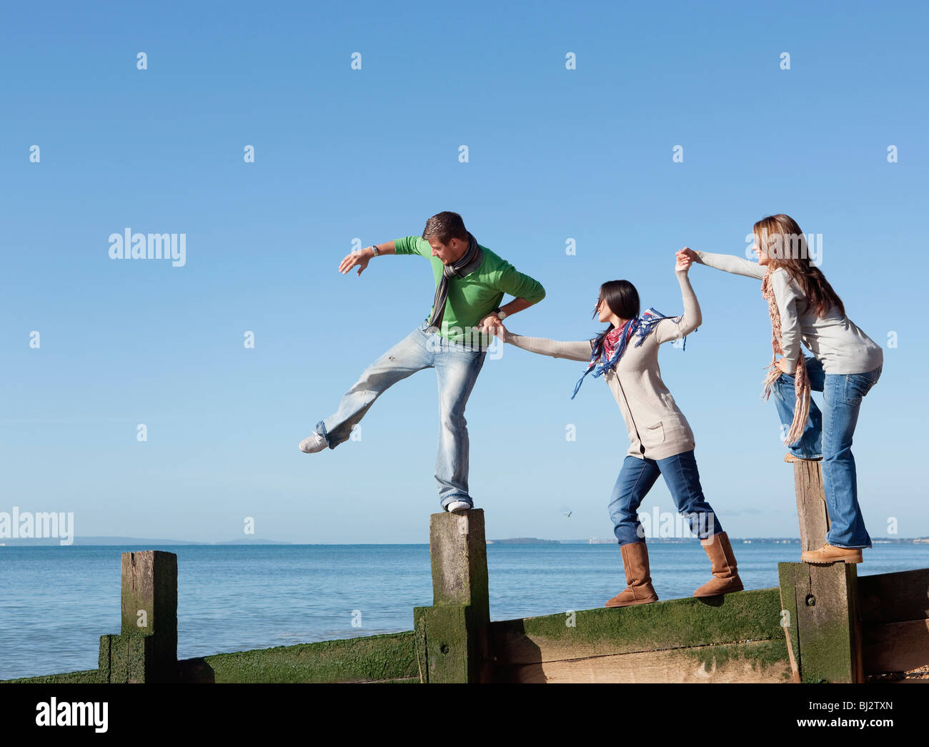 People balancing on jetty Stock Photo - Alamy
