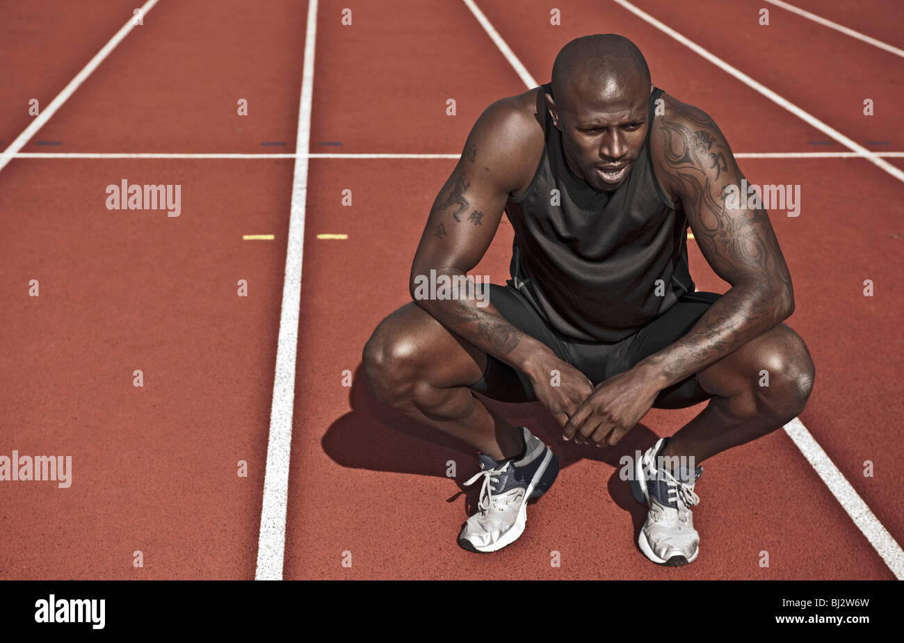 male athlete crouching in despair Stock Photo - Alamy