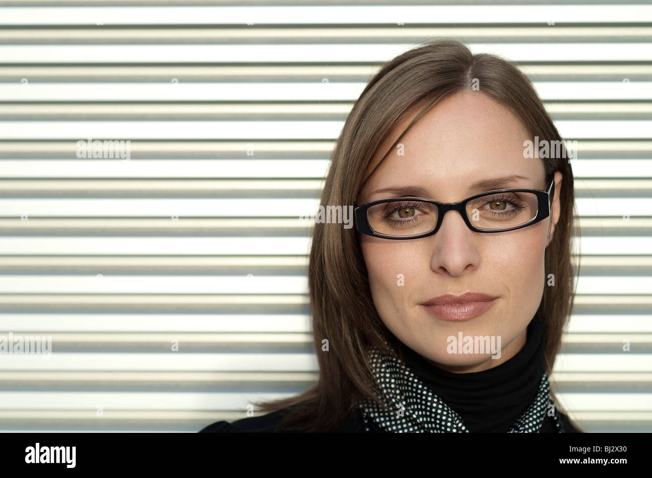 Portrait of a woman against shutters Stock Photo - Alamy