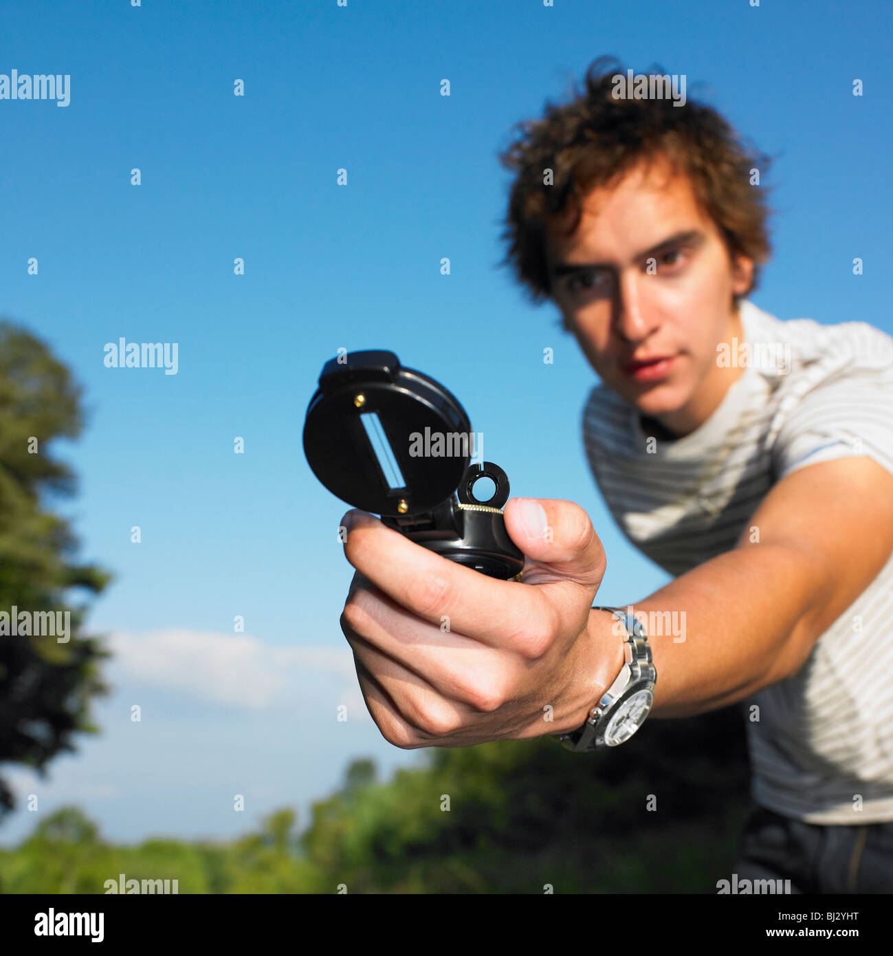 Man looking at compass Stock Photo - Alamy