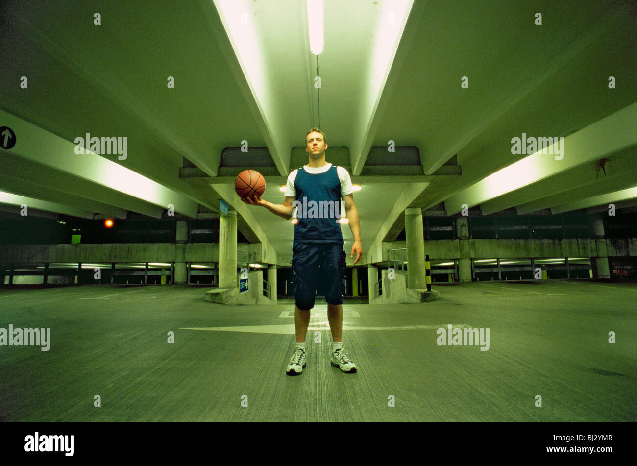 man holding basketball in car park Stock Photo - Alamy