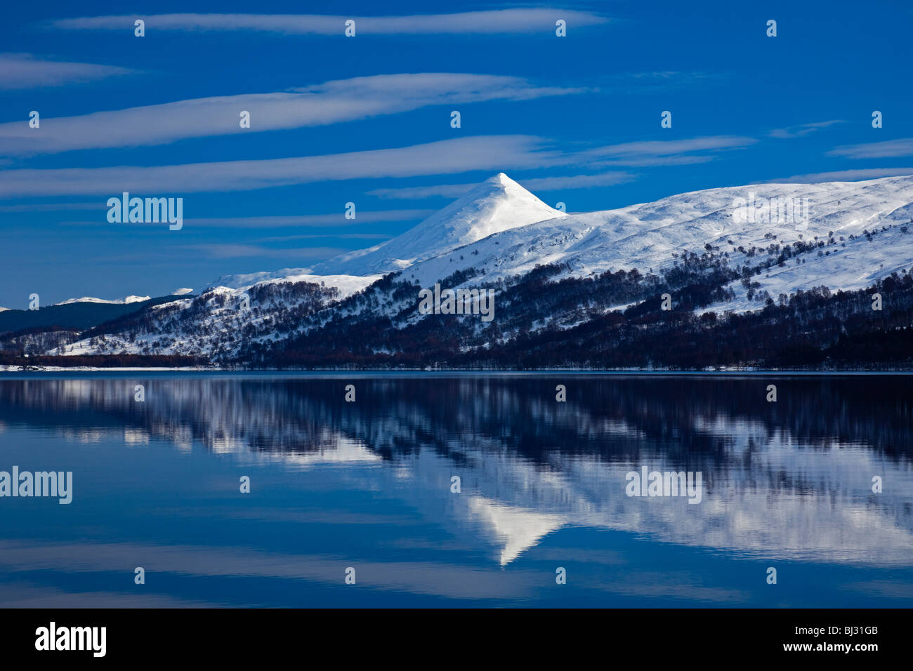 Schiehallion mountain with snow capped peaks reflected in Loch Rannoch ...