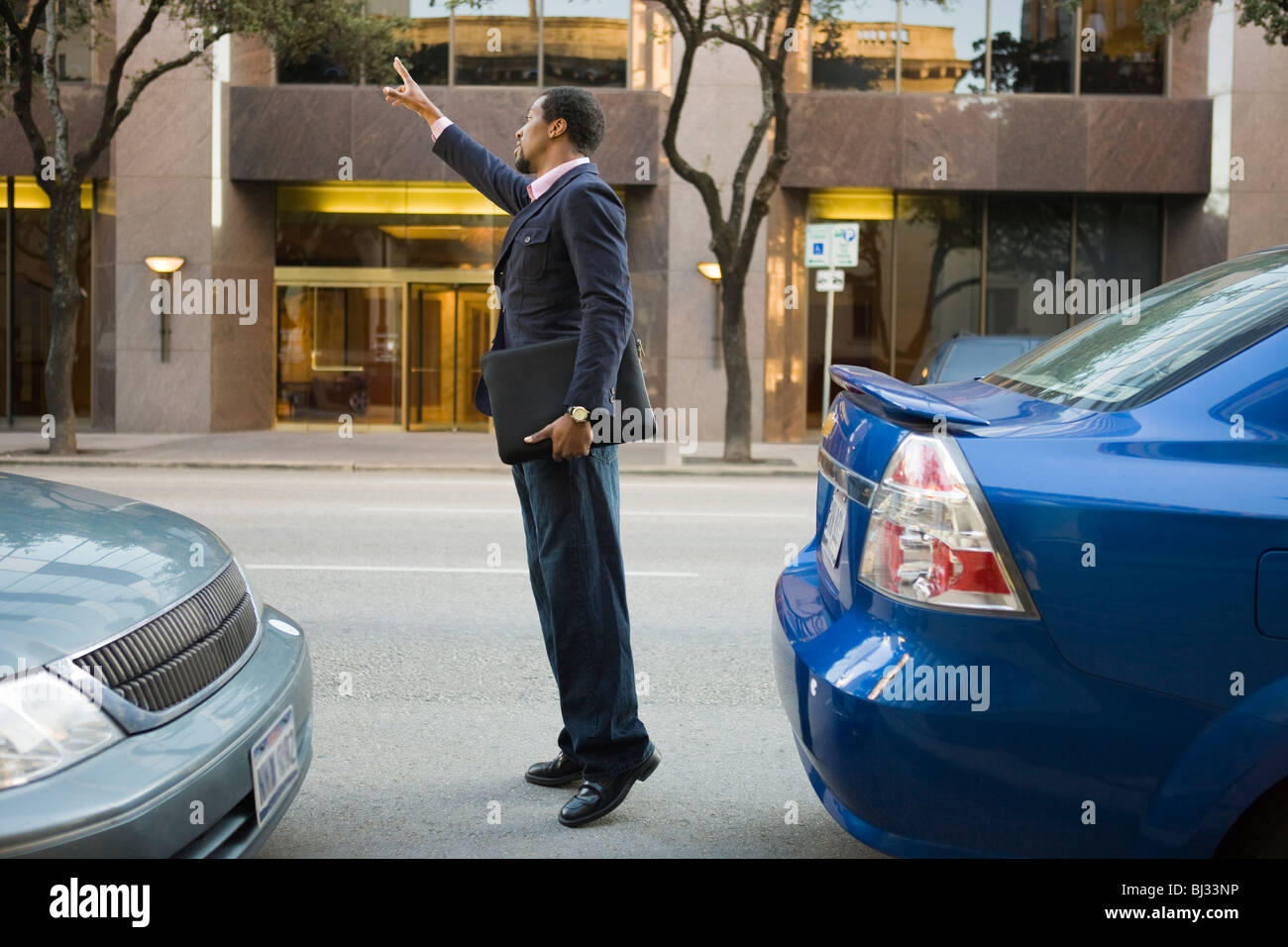 businessman signaling for taxi Stock Photo - Alamy