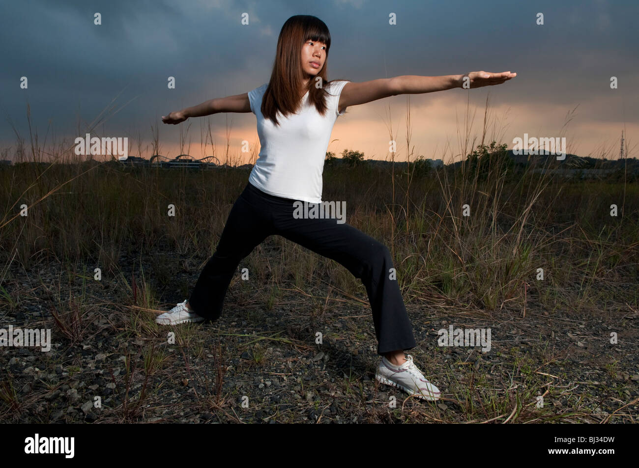 asian girl performing yoga during sunset Stock Photo - Alamy