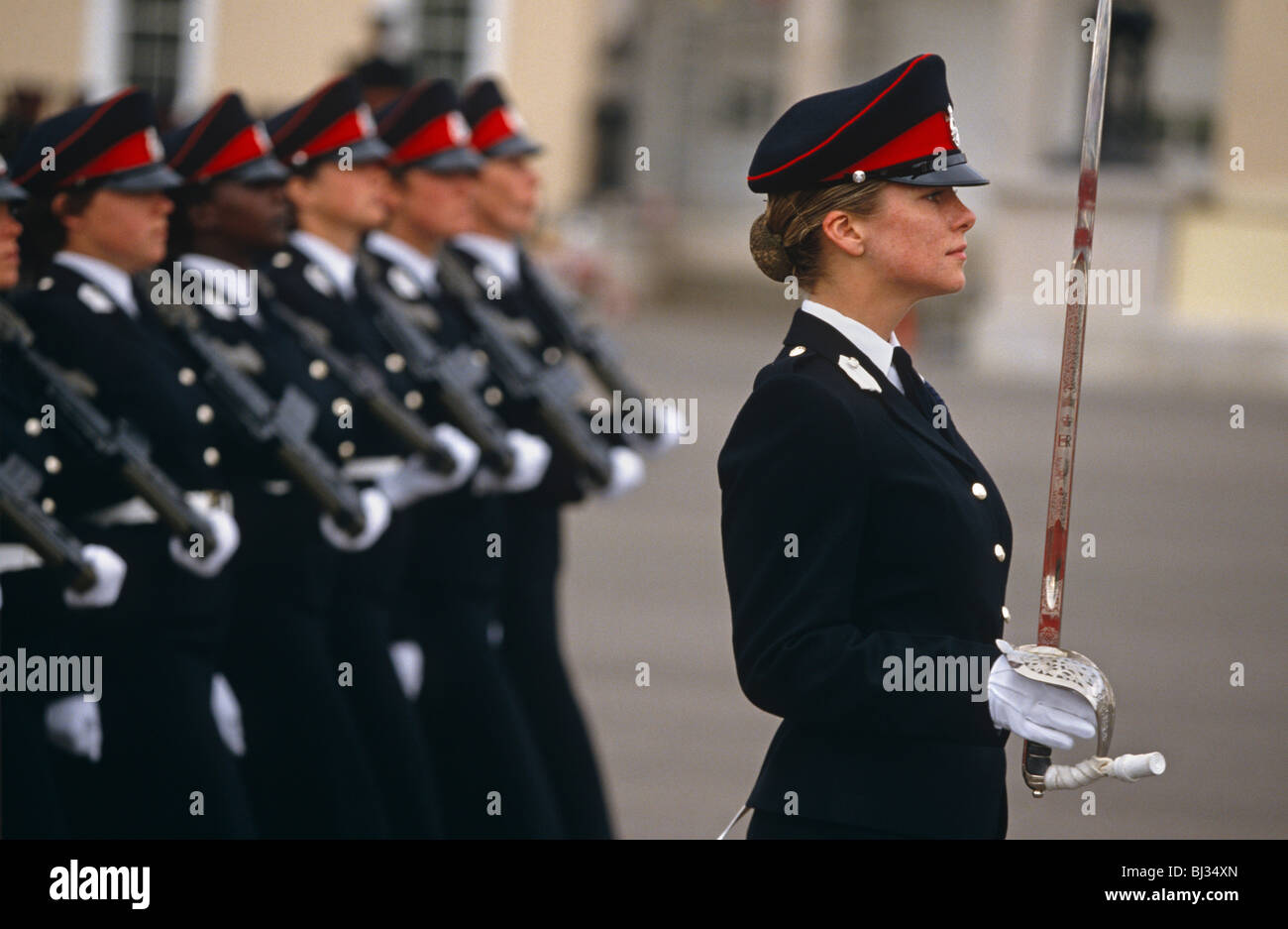 Female officer cadets march in line with their weapons on shoulders ...