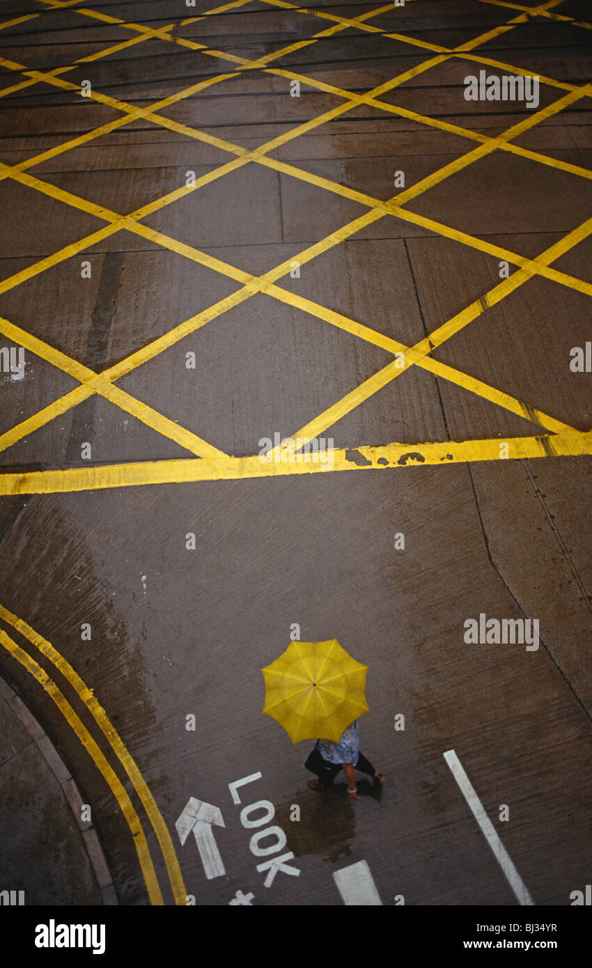 A pedestrian crosses a zebra crossing with a matching yellow grid box ...