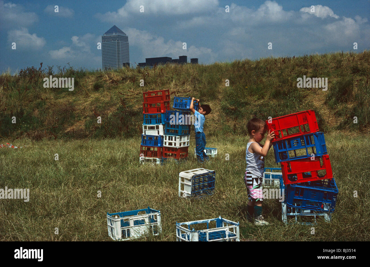 Two young boys concentrate on piling plastic bottle crates on top of ...