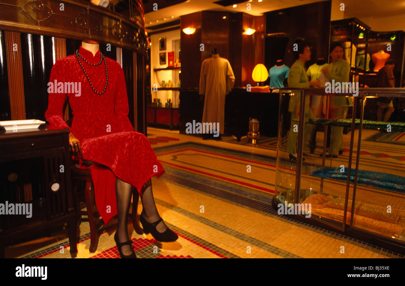 An elegant but headless life-size clothing mannequin seated on a chair ...