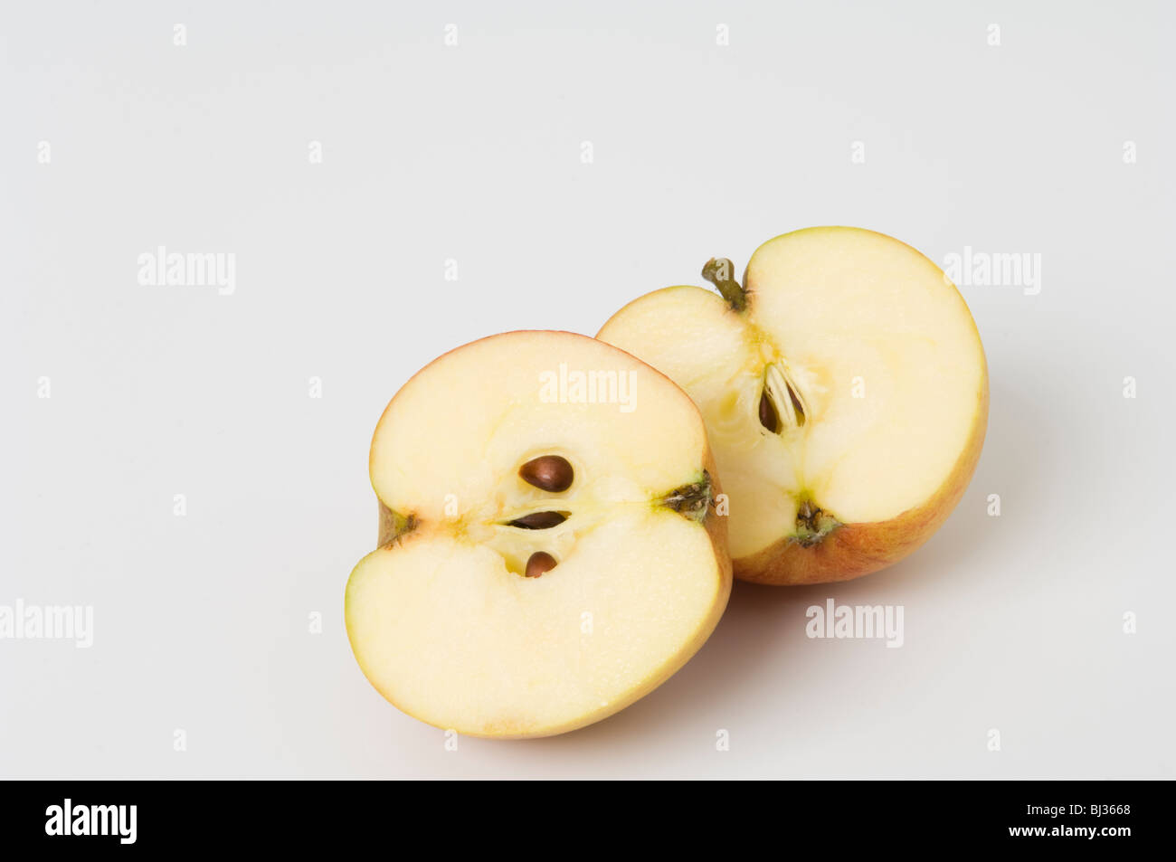Apple cut into two halves Stock Photo - Alamy