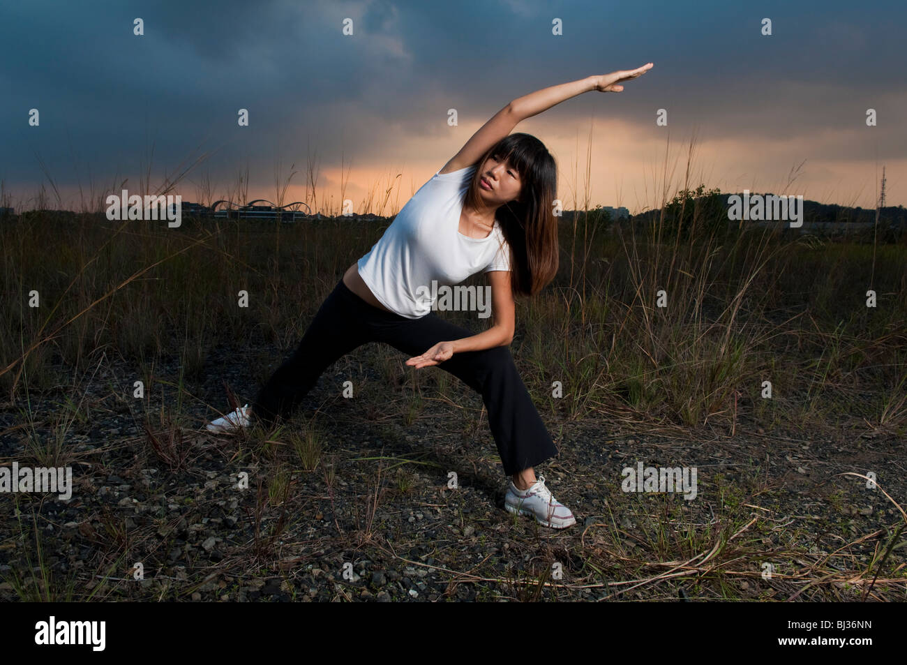 asian girl performing yoga during sunset Stock Photo - Alamy