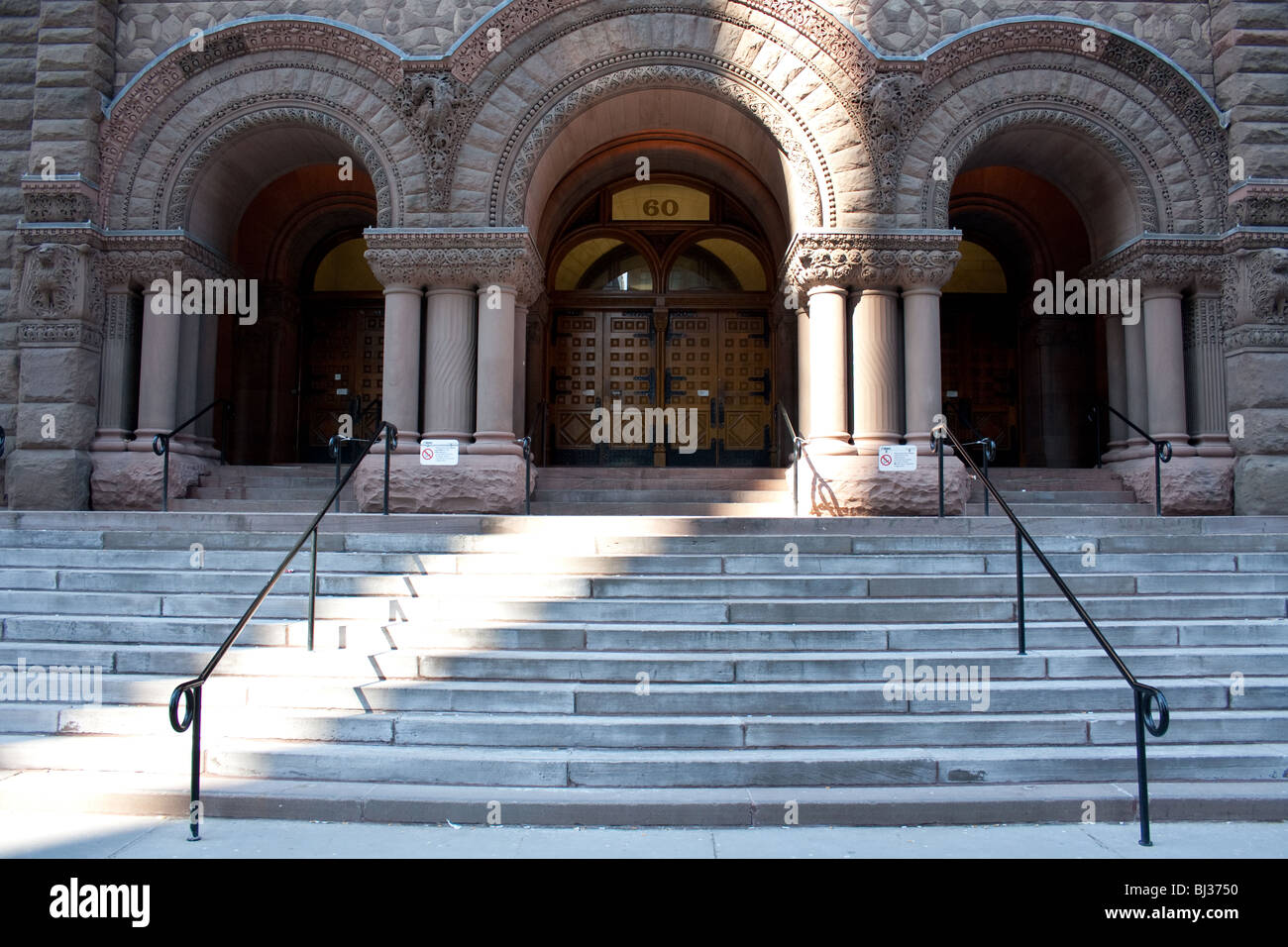 The front entrance of old Toronto city hall with a ray of evening light ...