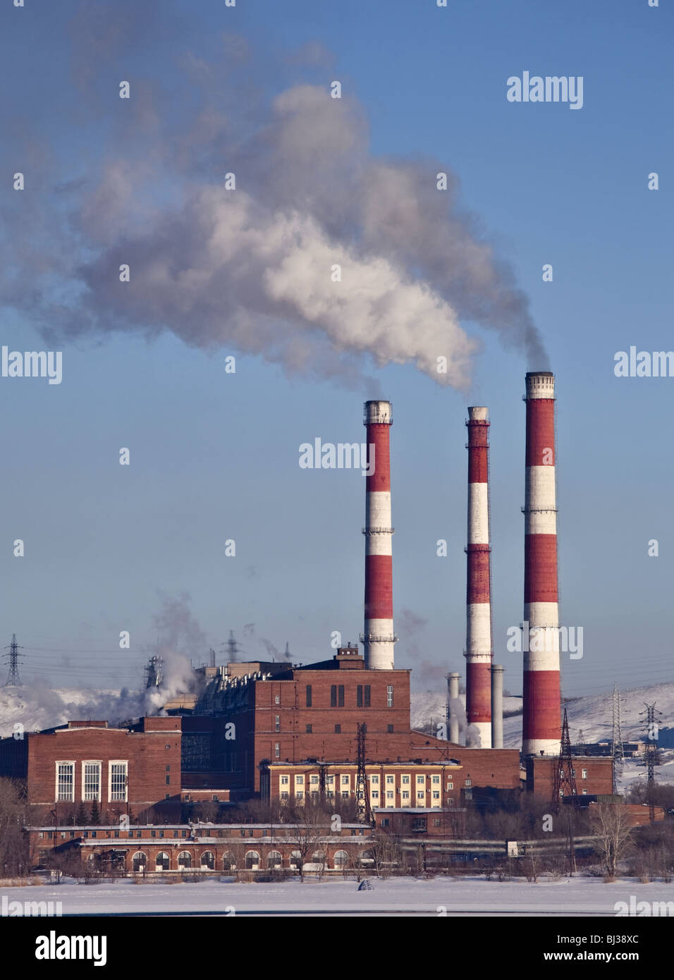 Factory building with three smoking chimneys Stock Photo - Alamy