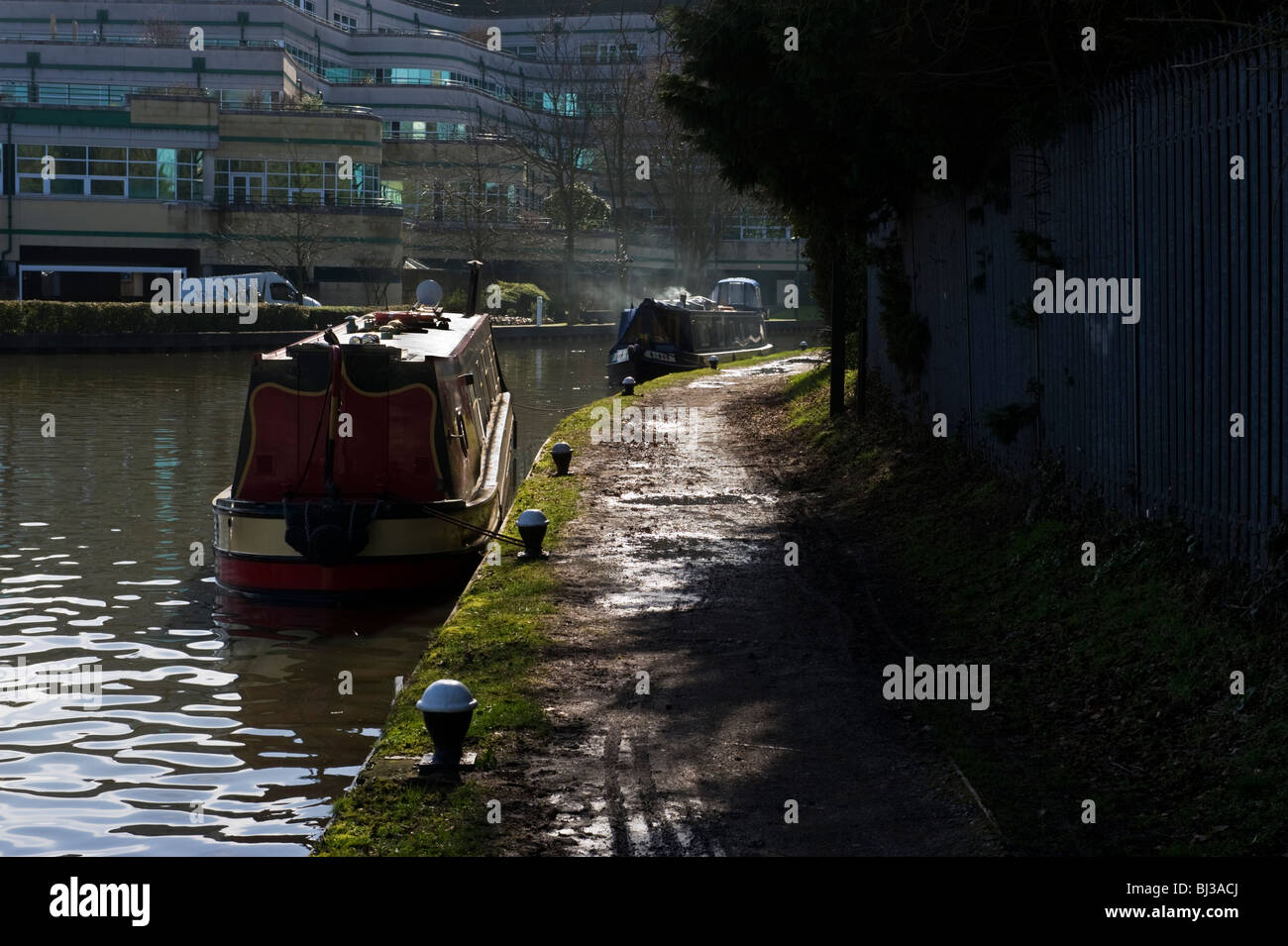 Narrow boat moored by a towpath on the side of the Grand Union canal at Uxbridge West London ...