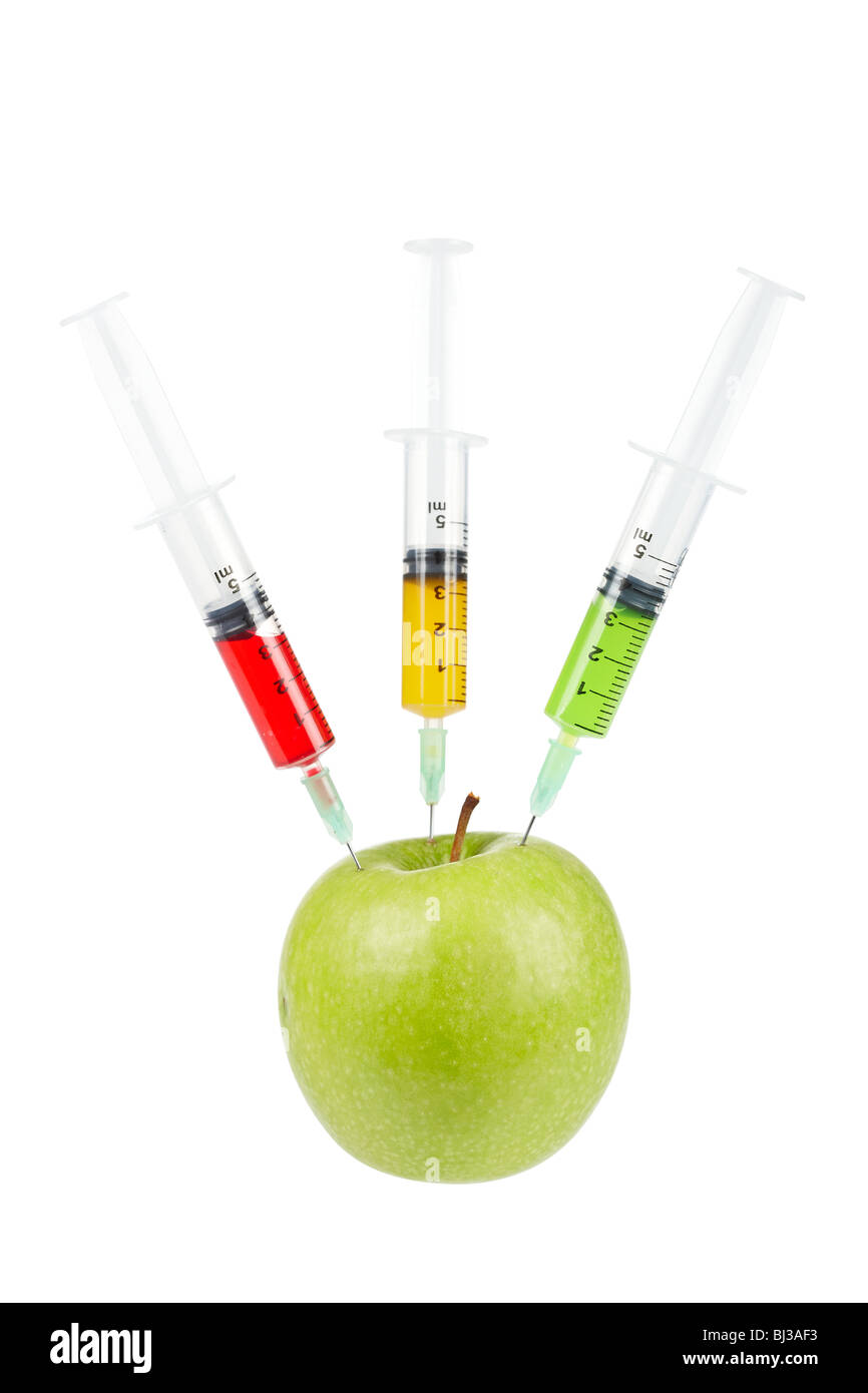 A green apple being injected with three syringes containing colour ...