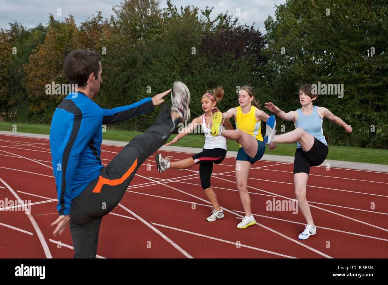 3 female athletes and trainer Stock Photo - Alamy