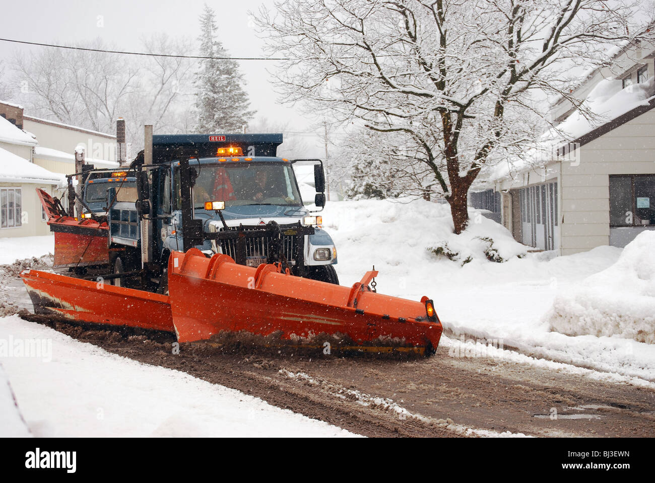 Snow plows in town attack large snowfall Stock Photo - Alamy