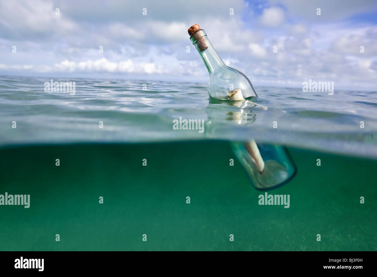 Message in a bottle floating in ocean Stock Photo - Alamy