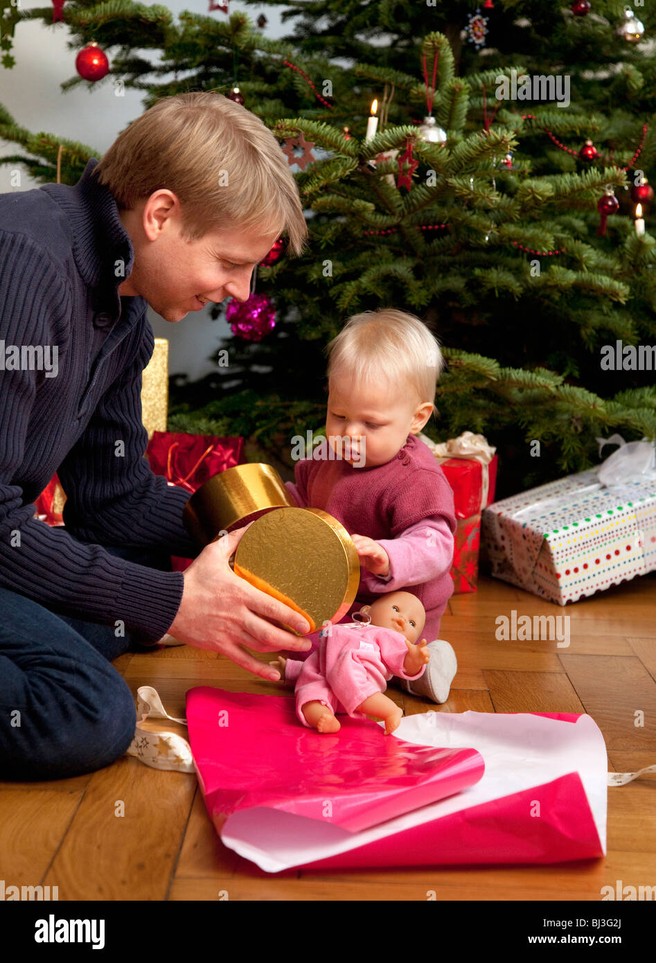 father, baby opening christmas present Stock Photo - Alamy