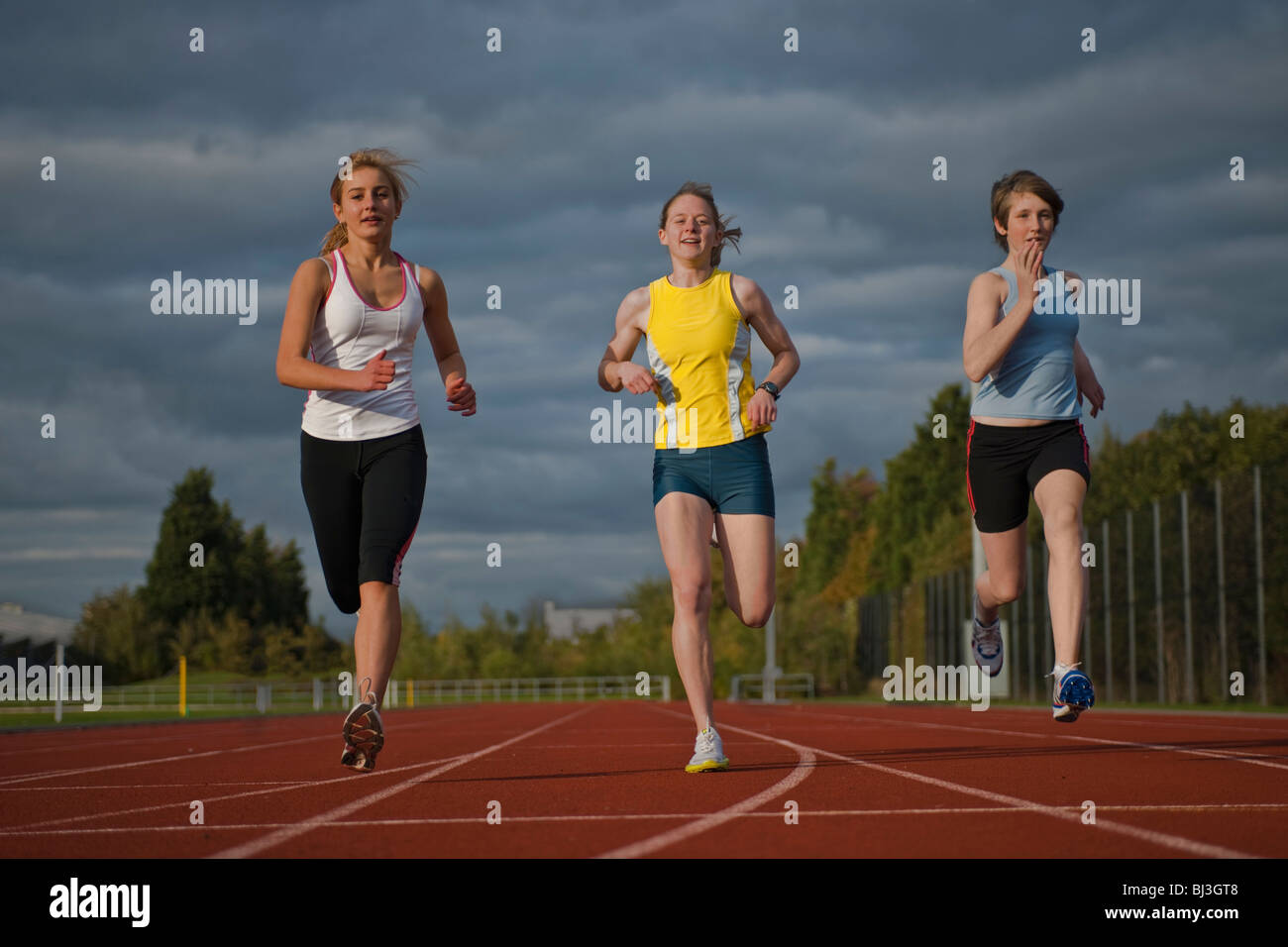 3 female athletes racing towards camera Stock Photo - Alamy