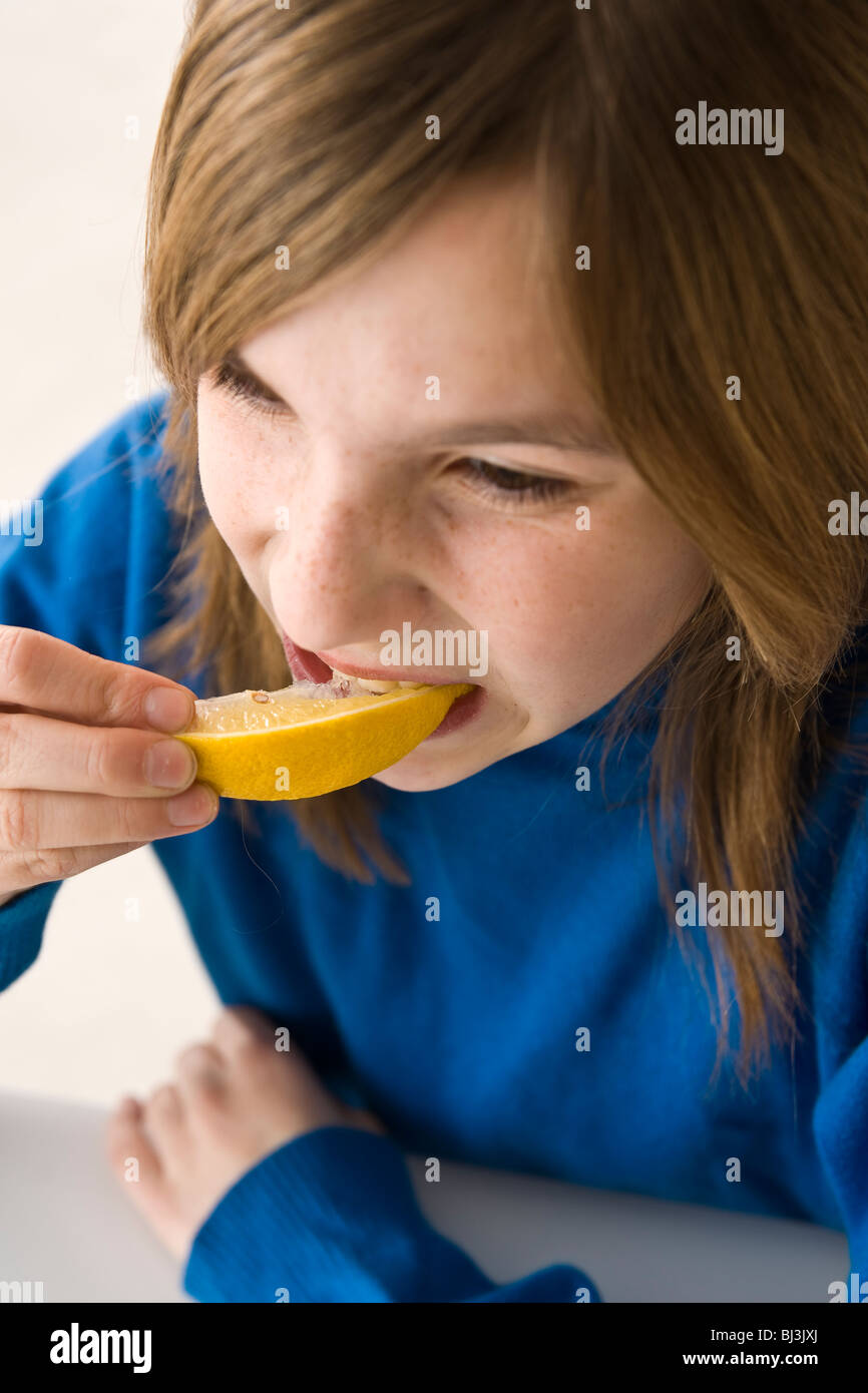 Girl biting into a lemon Stock Photo - Alamy