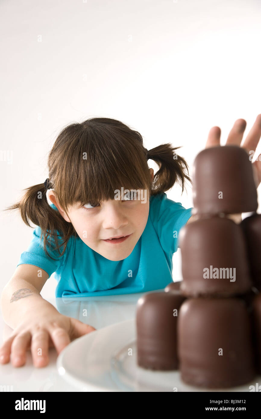 Little girl stealing a chocolate marshmallow Stock Photo - Alamy