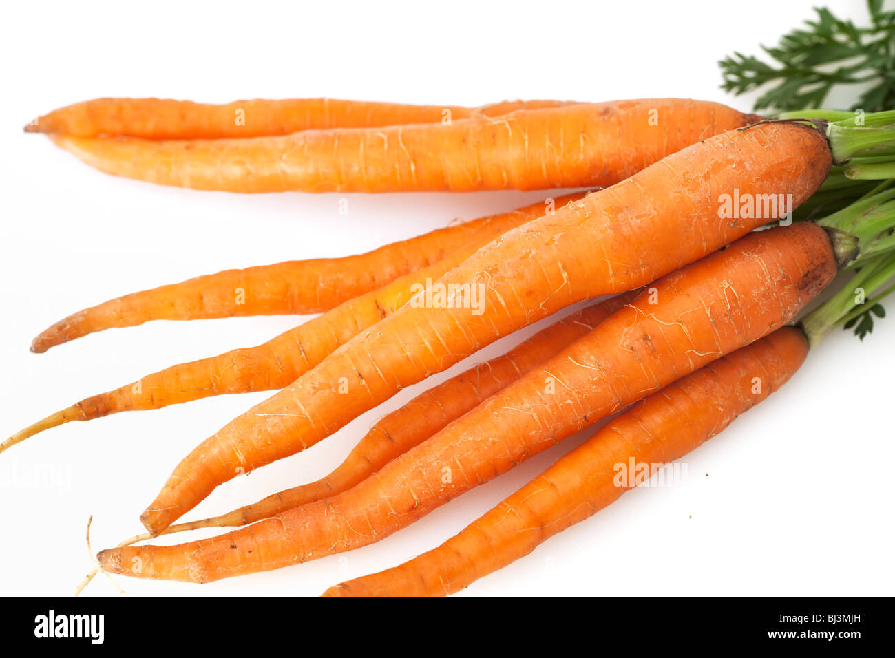A small bunch of fresh carrots on a white background Stock Photo - Alamy
