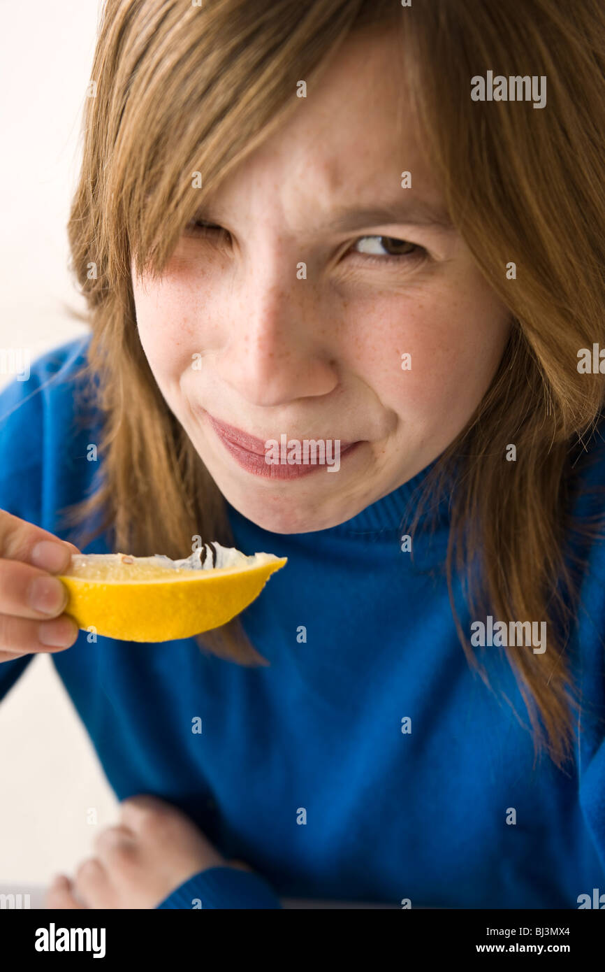 Girl biting into a lemon Stock Photo - Alamy