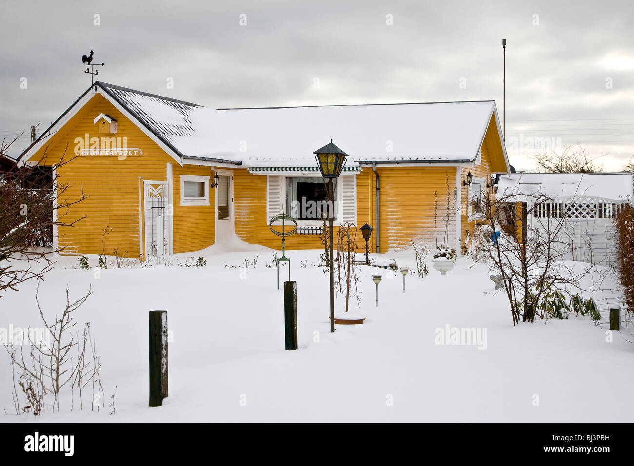 Yellow wooden house in a snow covered allotment garden, Denmark, Europe ...