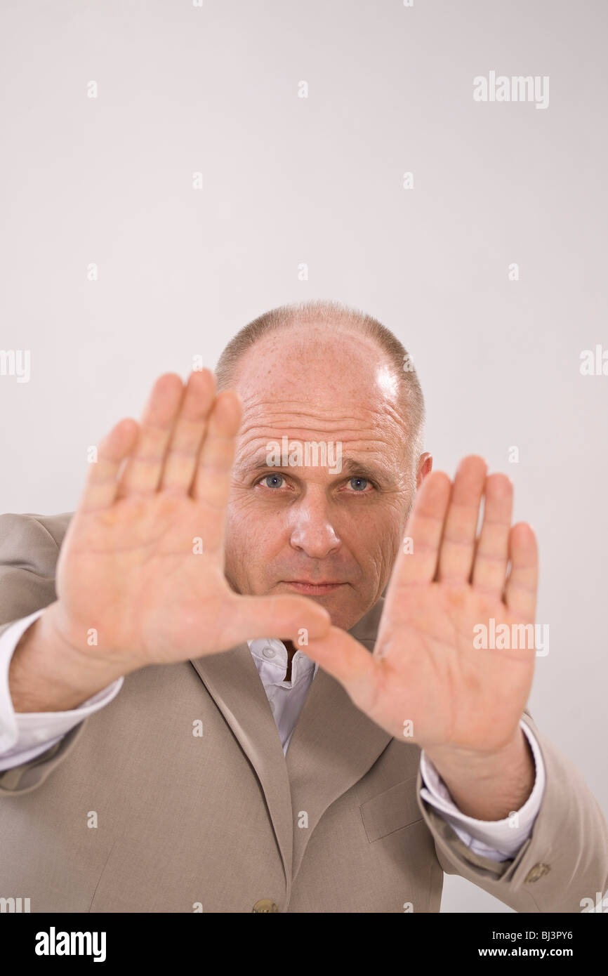 A man putting up both hands in front of his face to frame them Stock ...