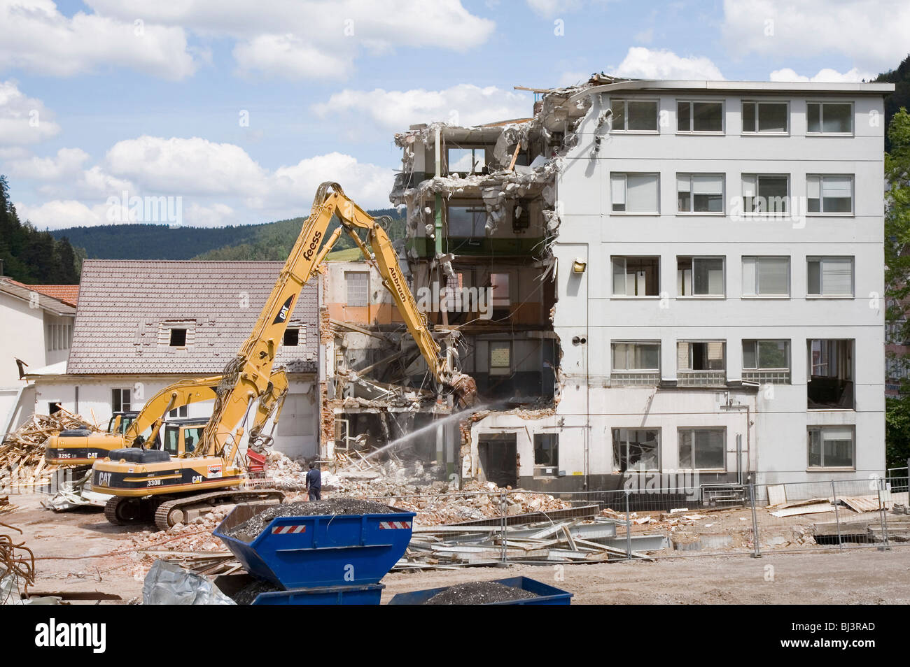 A digger pulling down a building, Triberg, Germany Stock Photo - Alamy