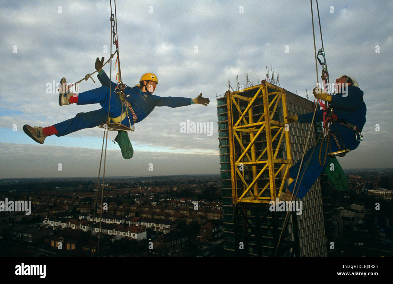 High above the skyline of North London member of a company of abseiling ...