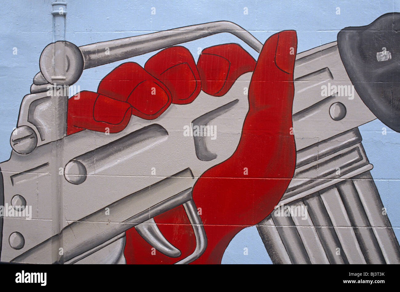 Apainted red hand that grips an Armalite automatic weapon which has ...