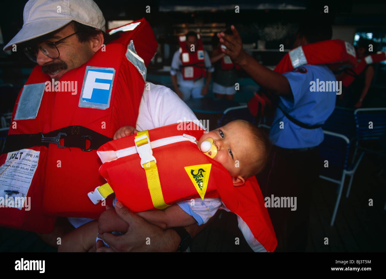A father and son practice wearing life-preservers during an evacuation ...