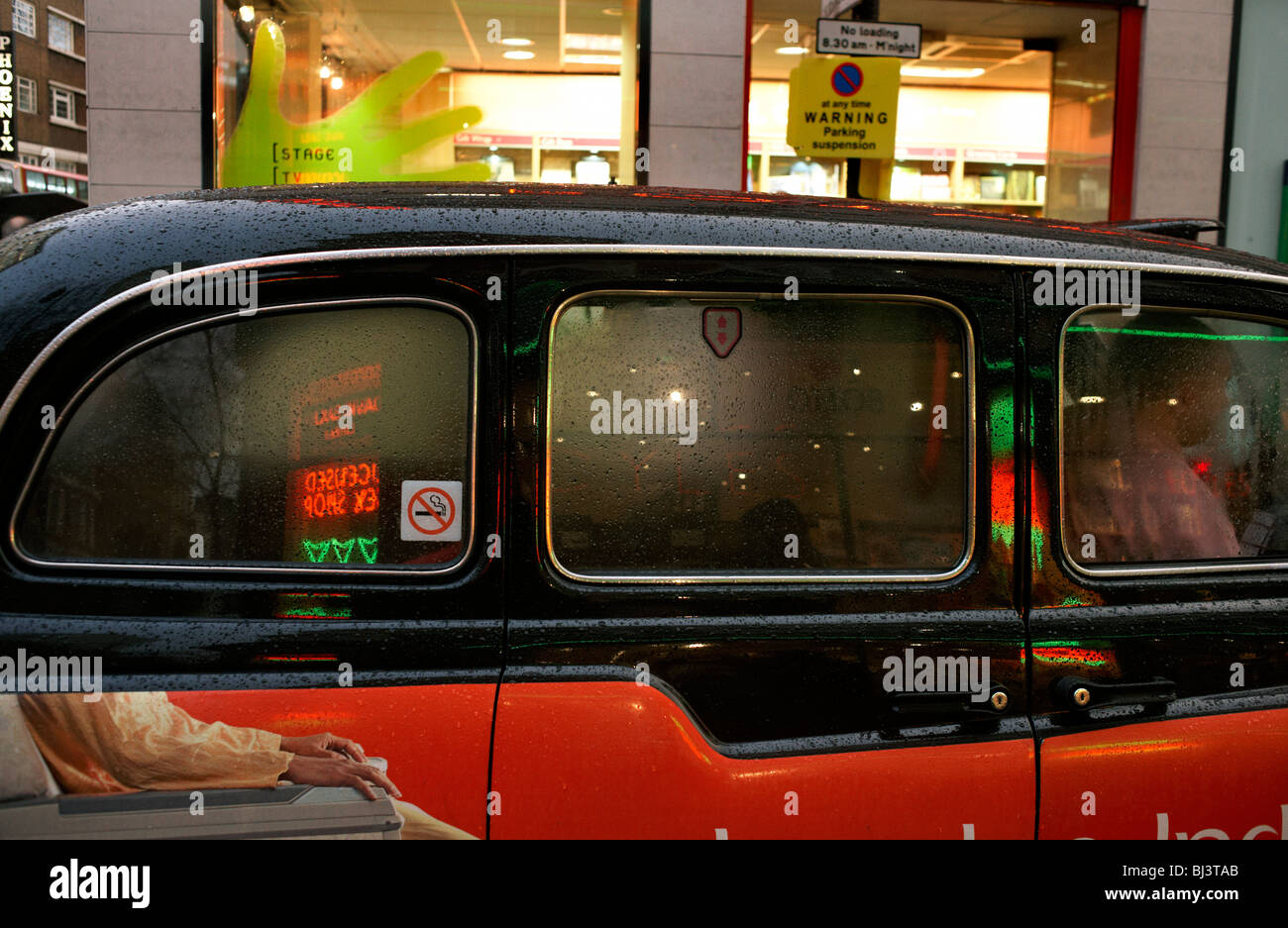 A London taxi cab is wet but after heavy rain while parked in a side ...