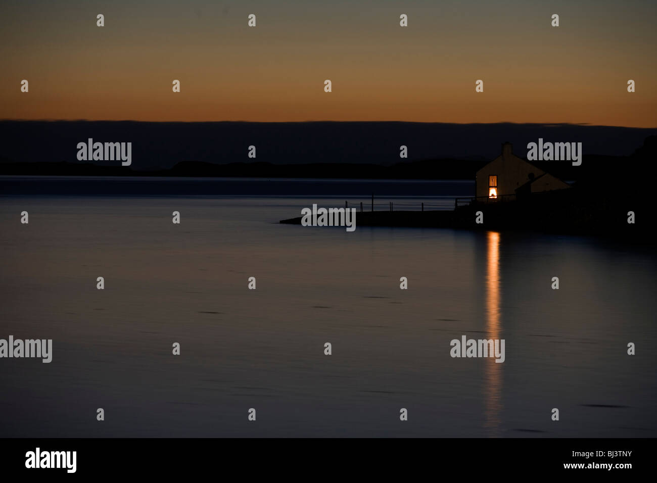 The last light of day fades on the still waters of Sgeir Nam Biast, a ...