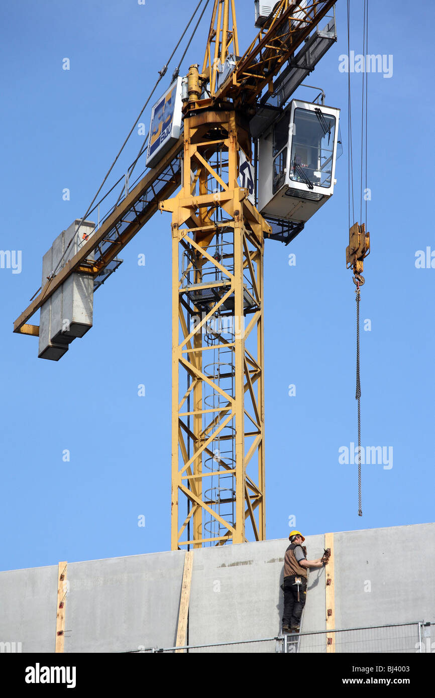 Construction worker and a crane on a building site, Berlin, Germany ...
