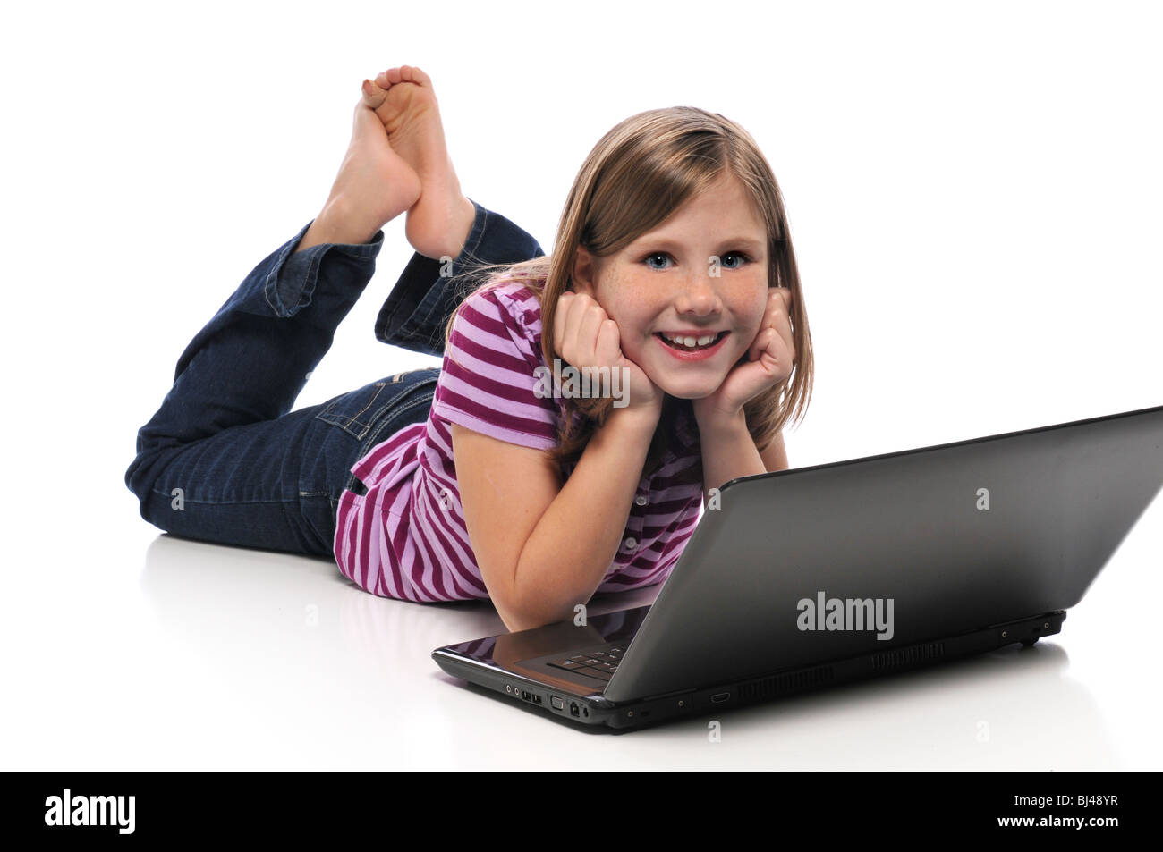 Little Girl with laptop computer lying on the floor isolated on white ...