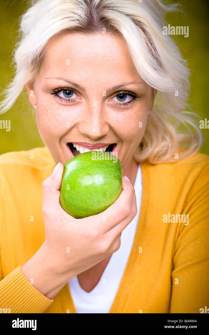 Young woman biting into apple Stock Photo - Alamy
