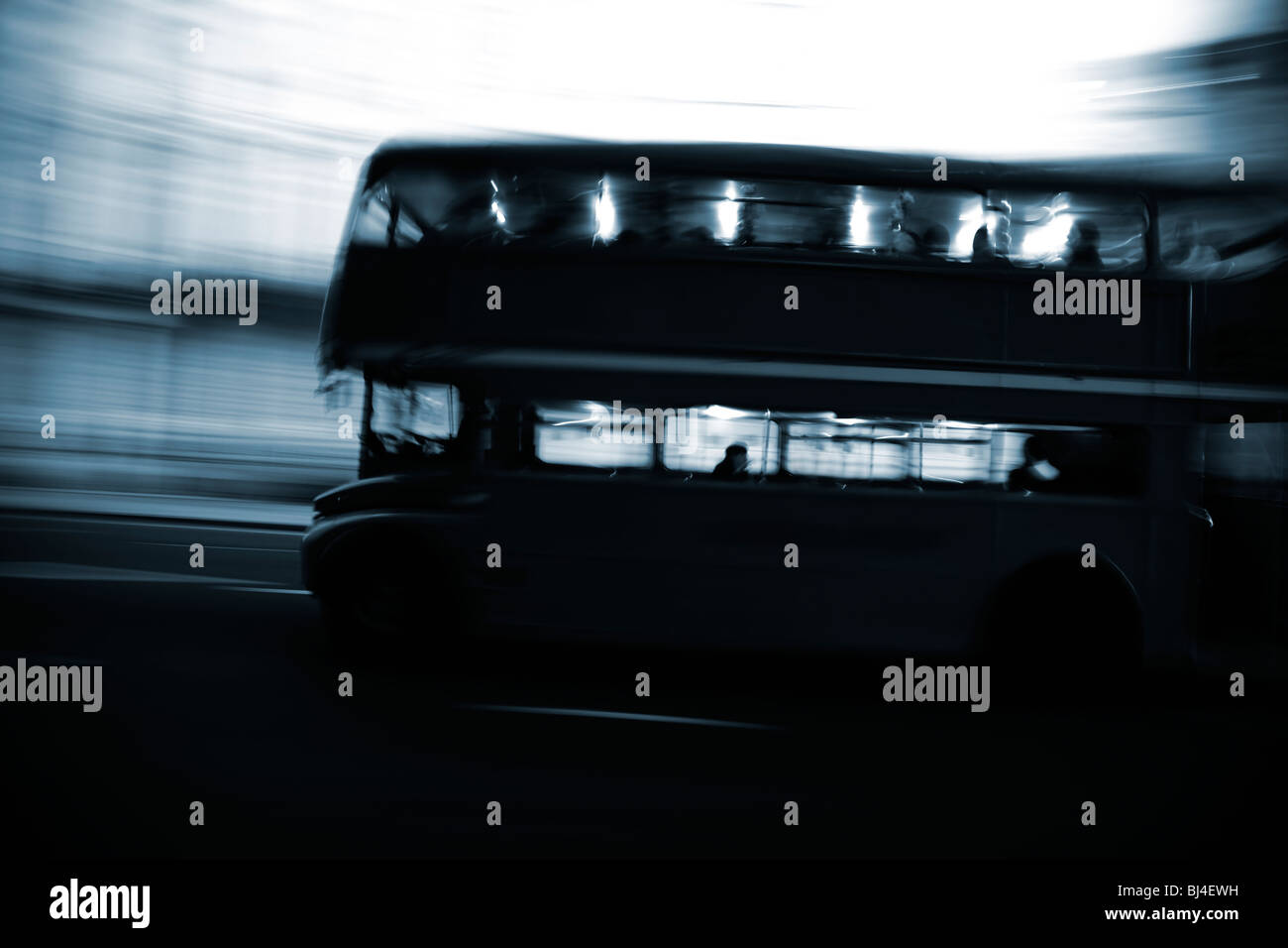 London double decker bus driving down street in London at night ...