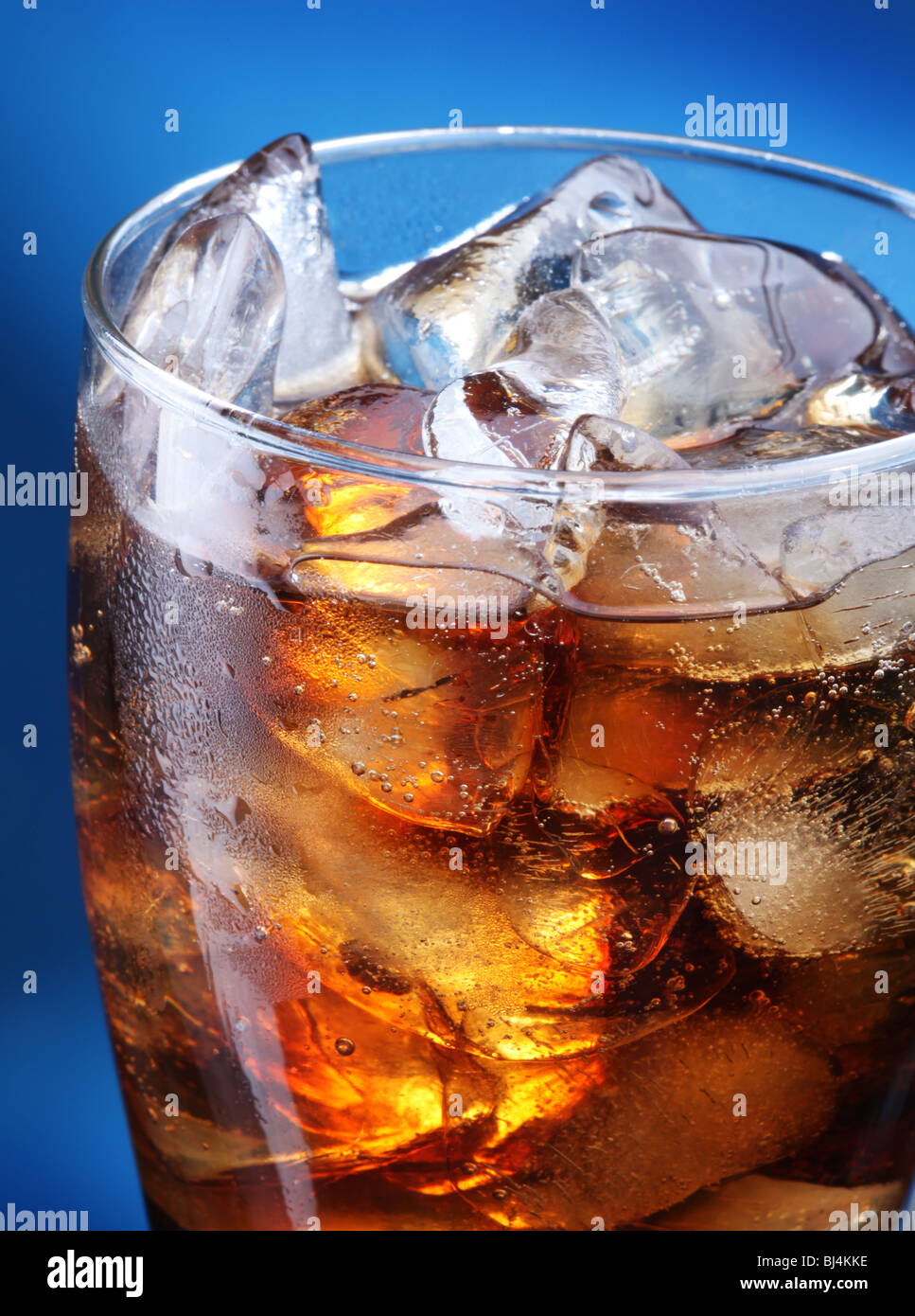 Glass of ice cola on a blue background Stock Photo - Alamy