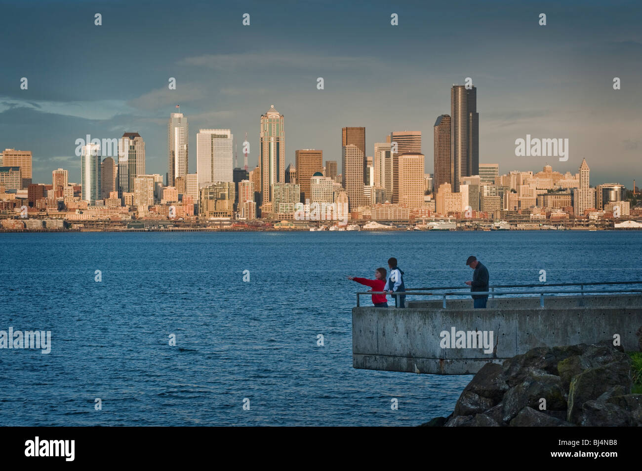 At an Alki Beach park, visitors enjoy the sunset over Elliott Bay and ...