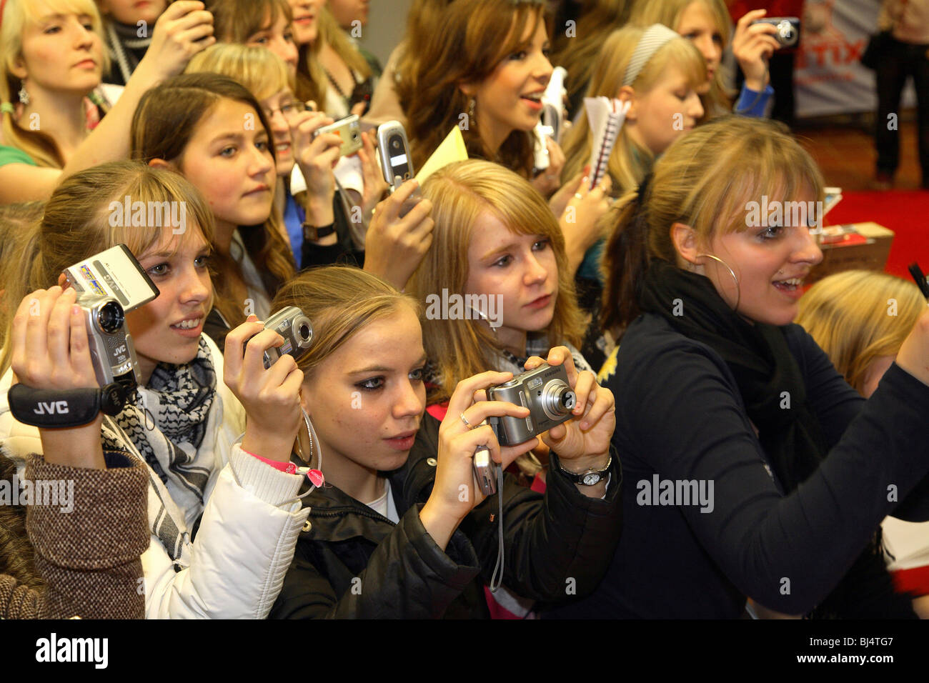 Crowd of girls taking photos, Berlin, Germany Stock Photo - Alamy