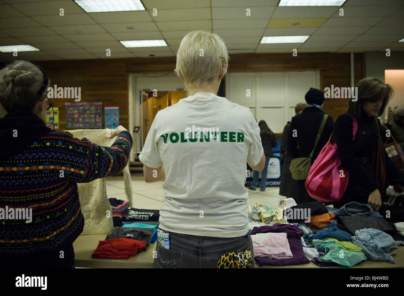 A volunteer puts out clothing at a free Stop 'N" Swap event in the ...