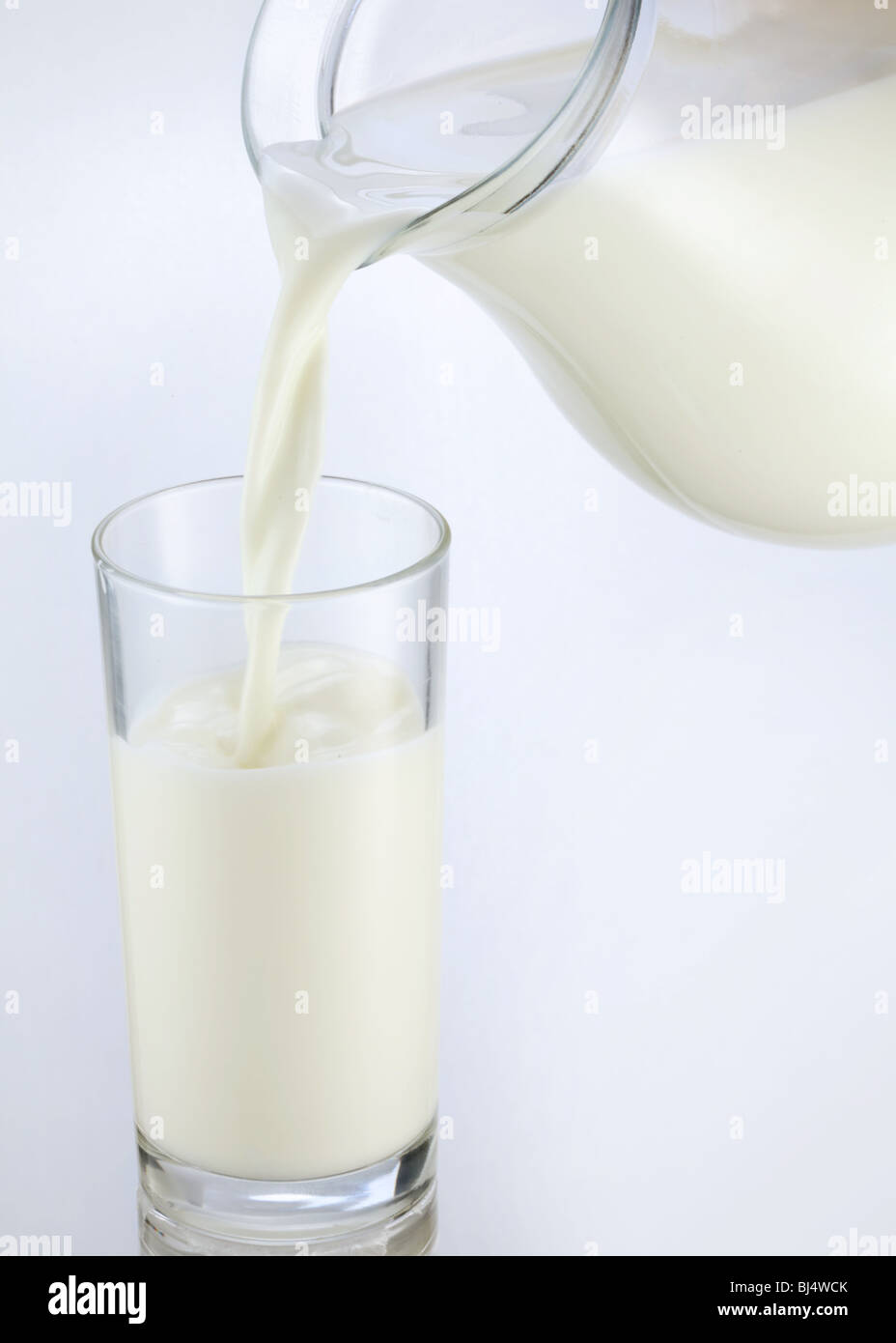 Pouring of milk from jar into a glass Stock Photo - Alamy