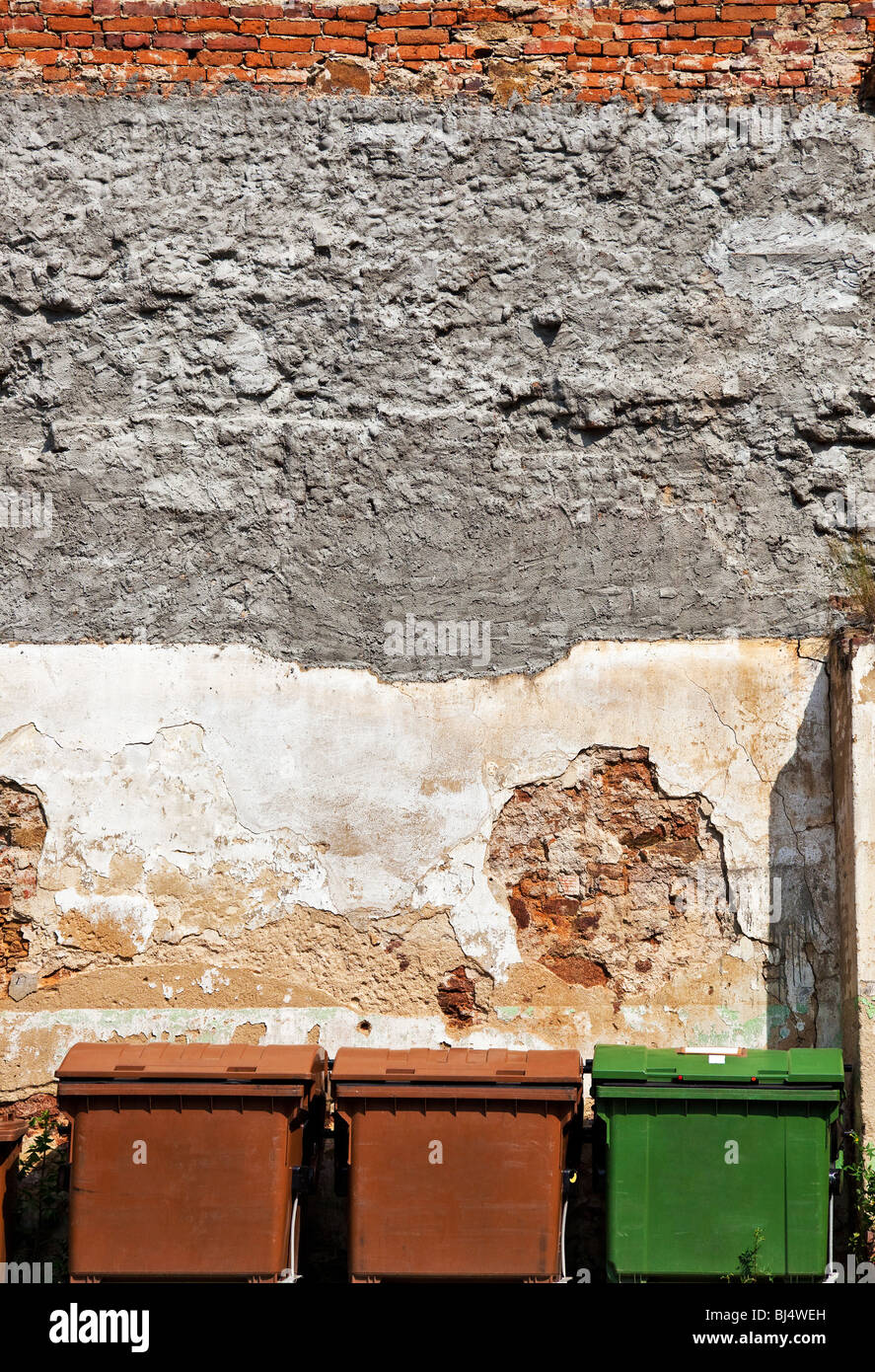 Three refuse bins on wall background Stock Photo - Alamy